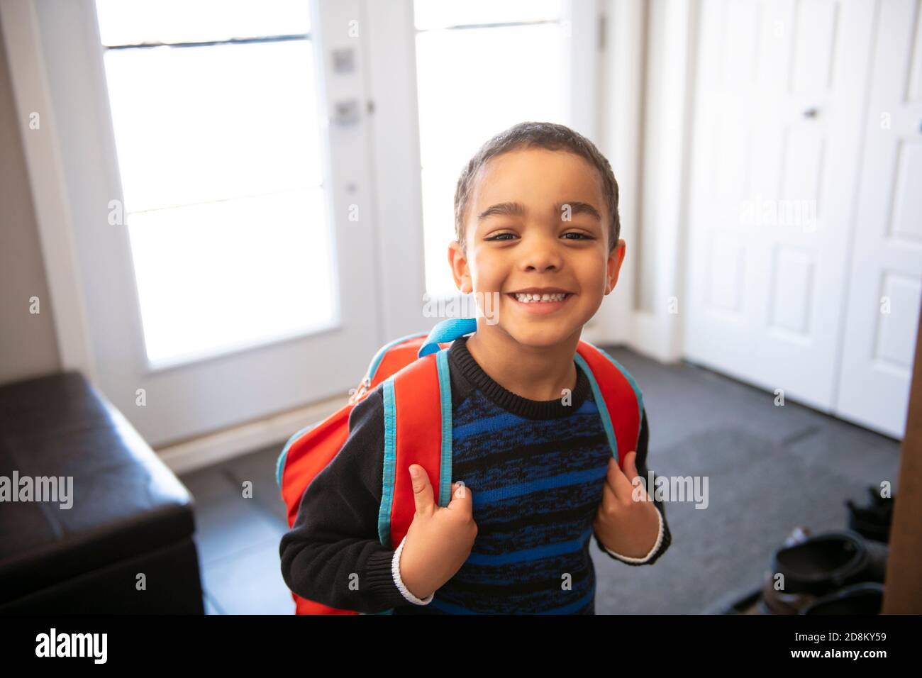 A child boy coming home passing through the door after school Stock ...