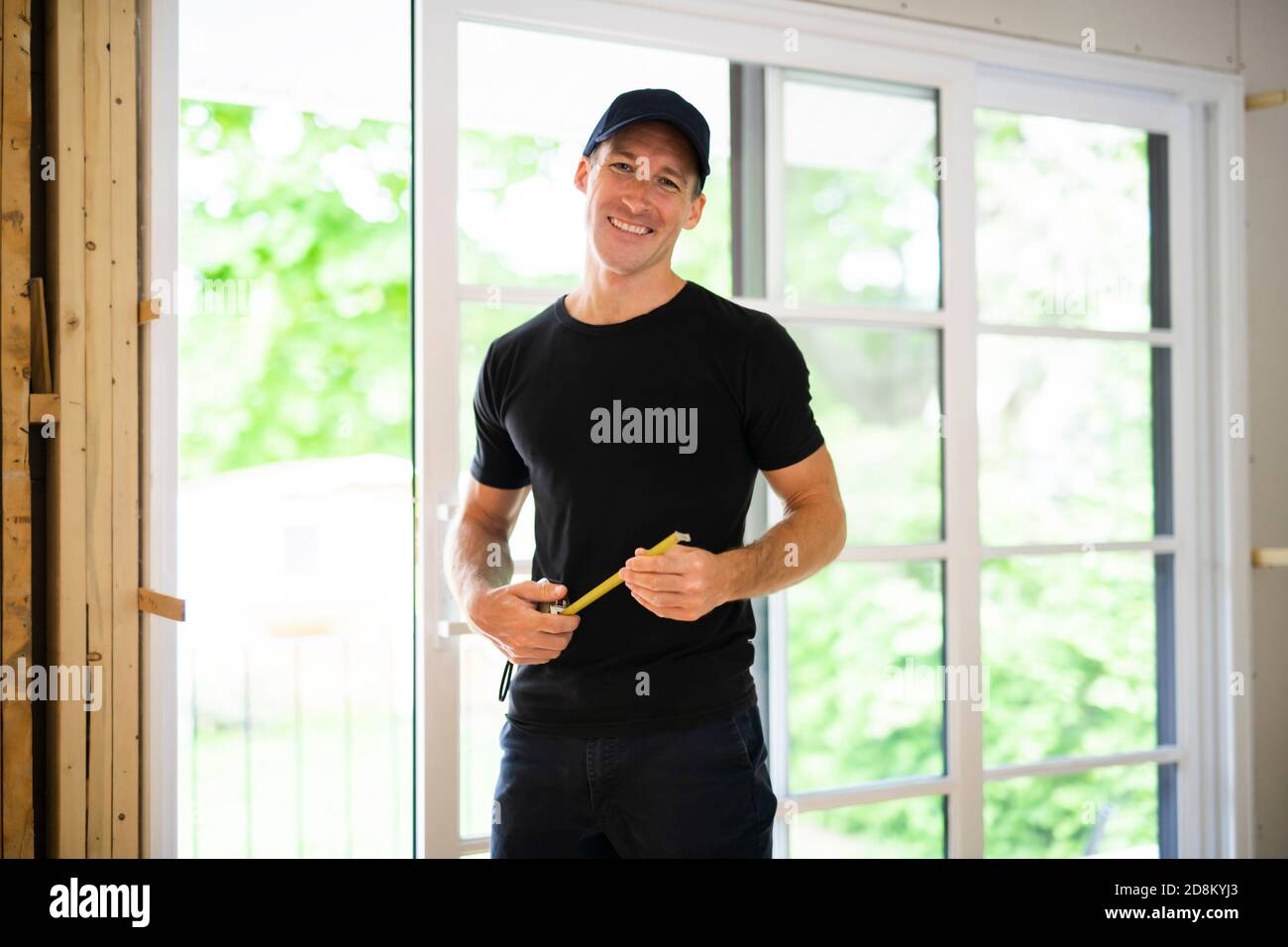 A handsome young man installing Double Sliding Patio Door in a new ...