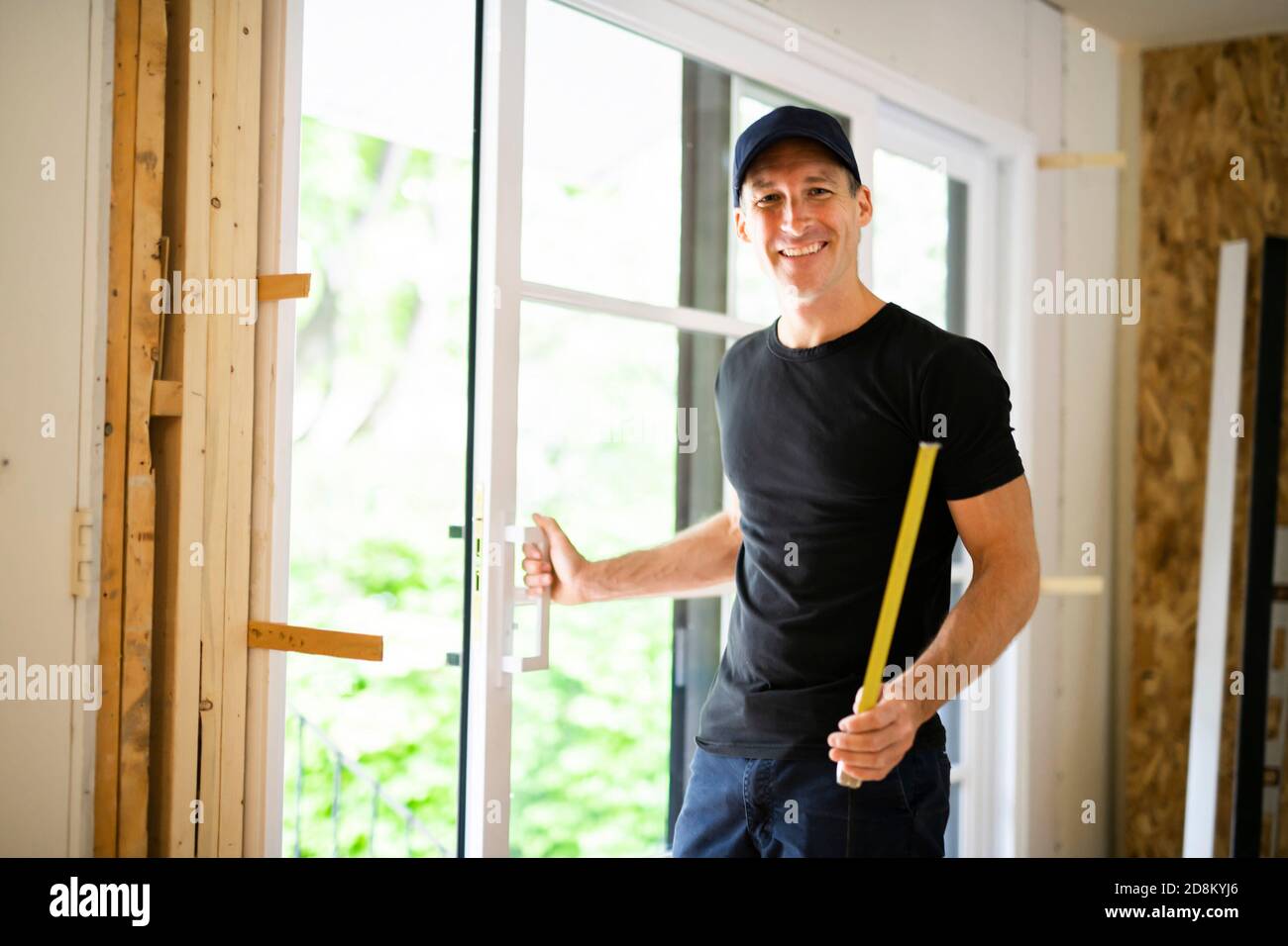 A handsome young man installing Double Sliding Patio Door in a new ...
