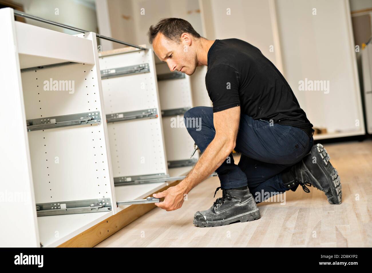 A Male Carpenter Drilling In Cabinet With Electric Cordless Drill Stock ...