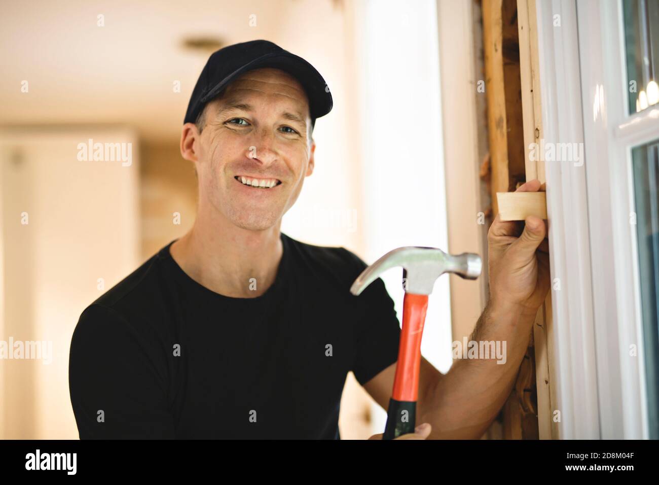 A handsome young man installing Double Sliding Patio Door in a new ...