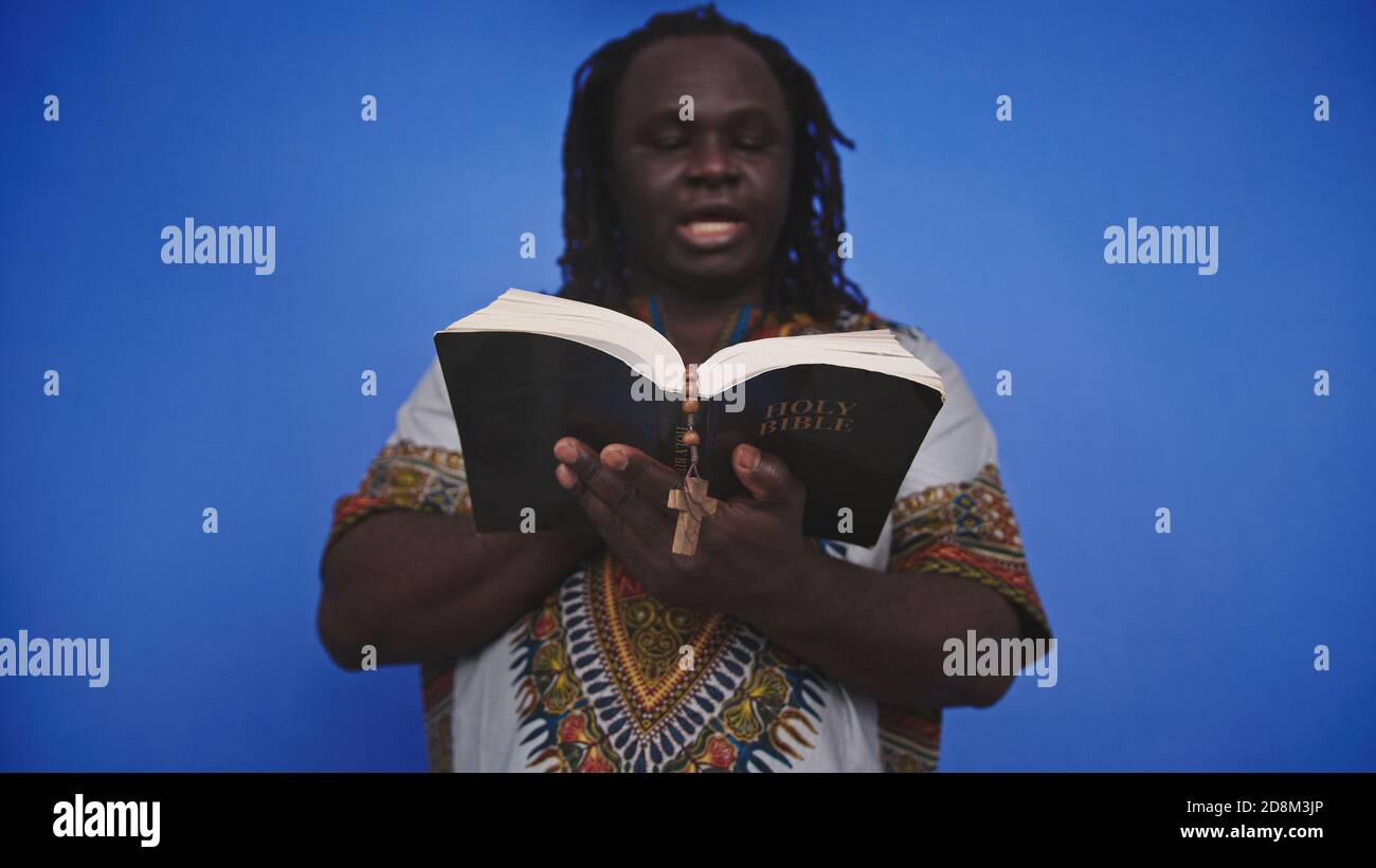 Portrait of african black man in traditional dress with rosary reading ...