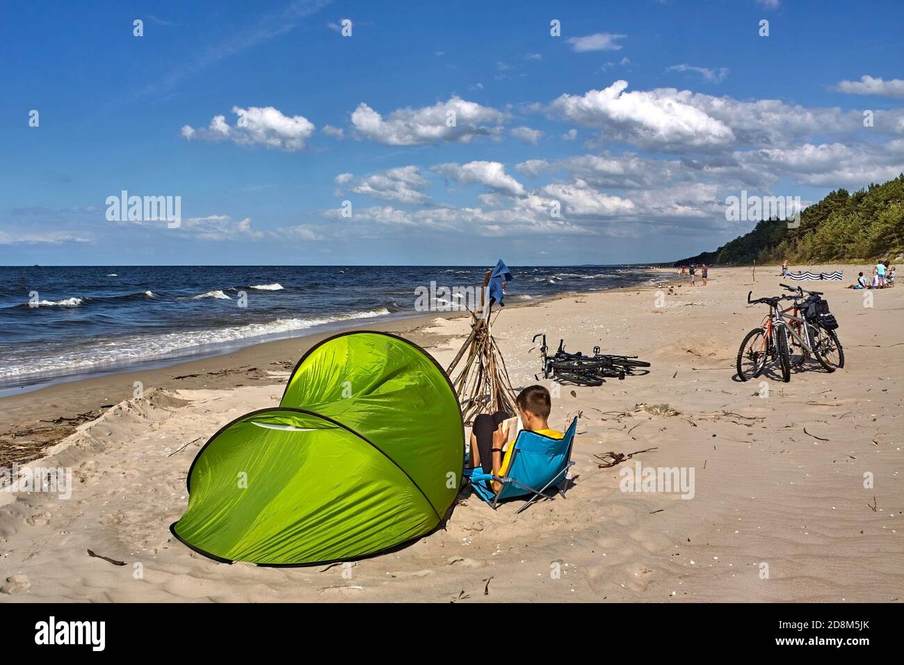 Tourist reading a book sitting in beach chair on a sea beach Stock ...