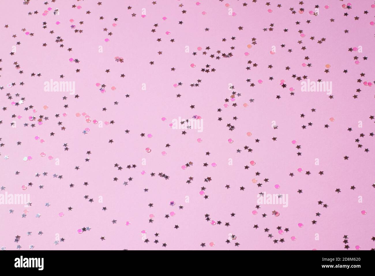 Pink sequins on a pink pastel background with confetti as asterisks ...