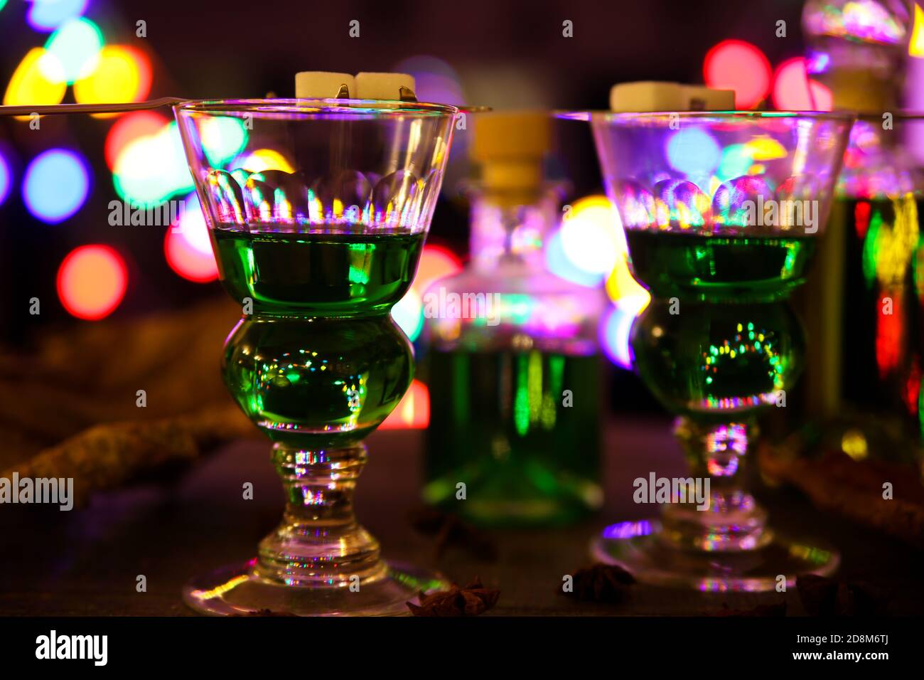 View on alcohol glasses and bottle with green absinthe drink, colorful ...