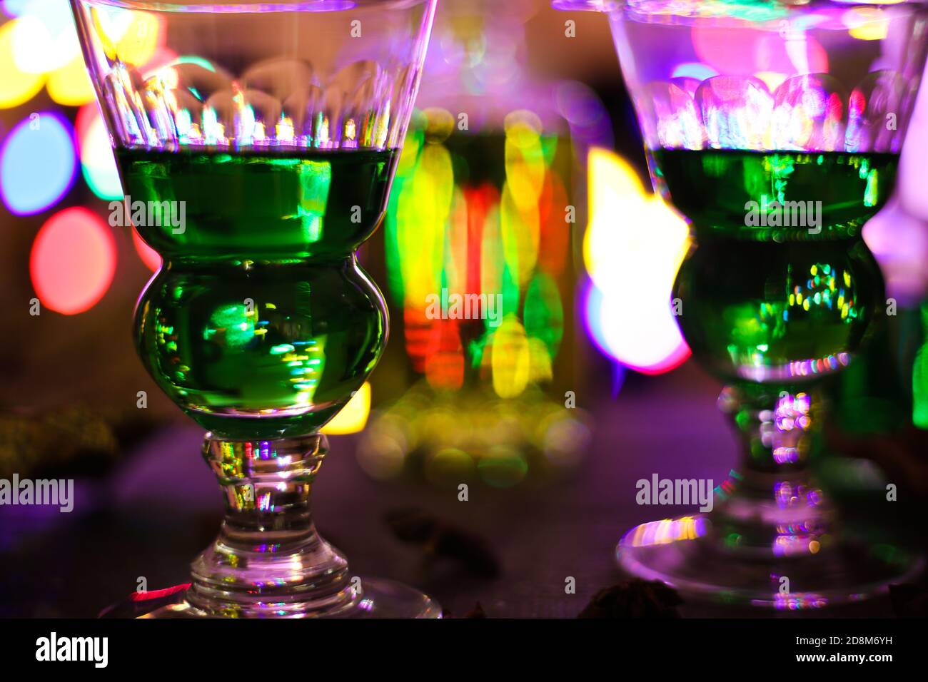 View on alcohol glasses and bottle with green absinthe drink, colorful ...