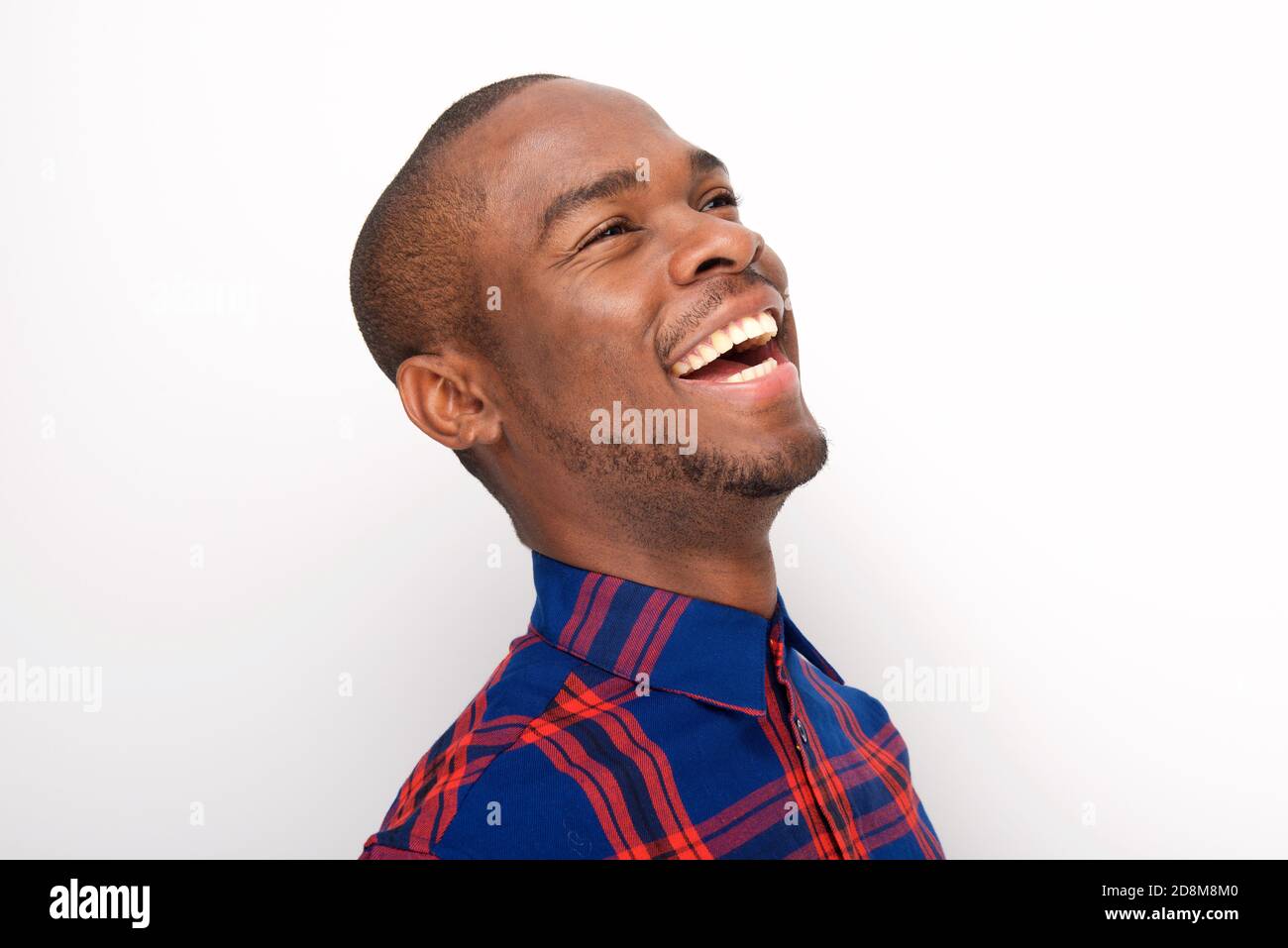 Close up side portrait of happy young black man laughing against white ...