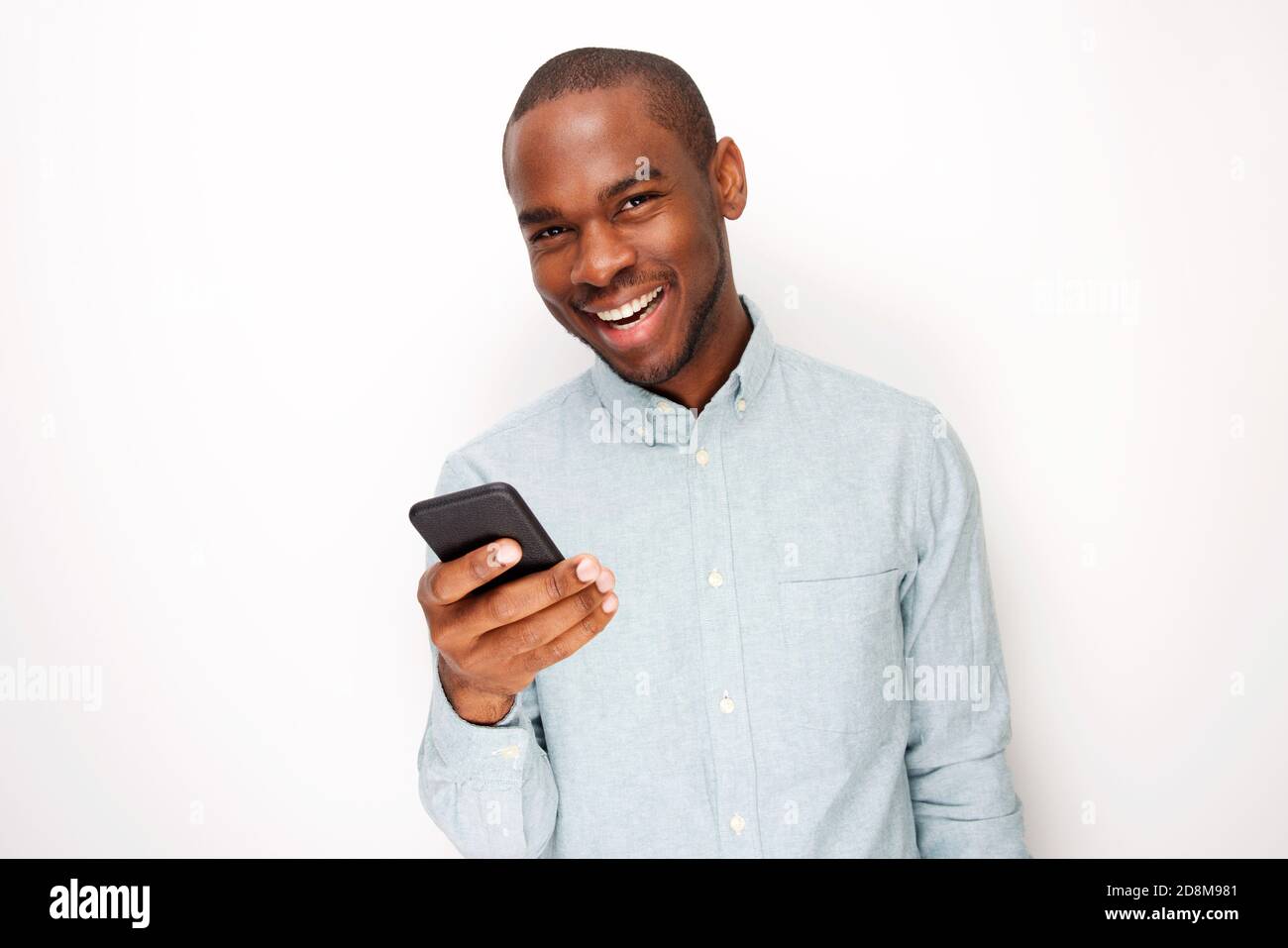 Portrait of handsome young black man holding mobile phone against white background Stock Photo ...