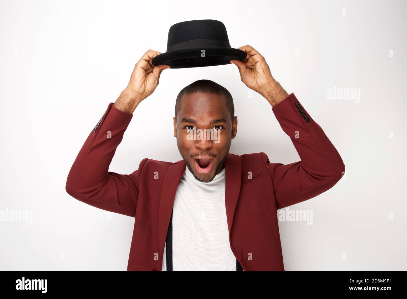 Portrait of happy young black man holding hat above his head Stock ...