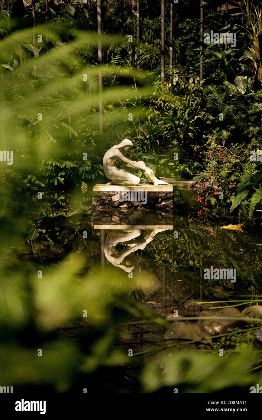 Stone statue of a sitting woman reflecting in water Stock Photo - Alamy