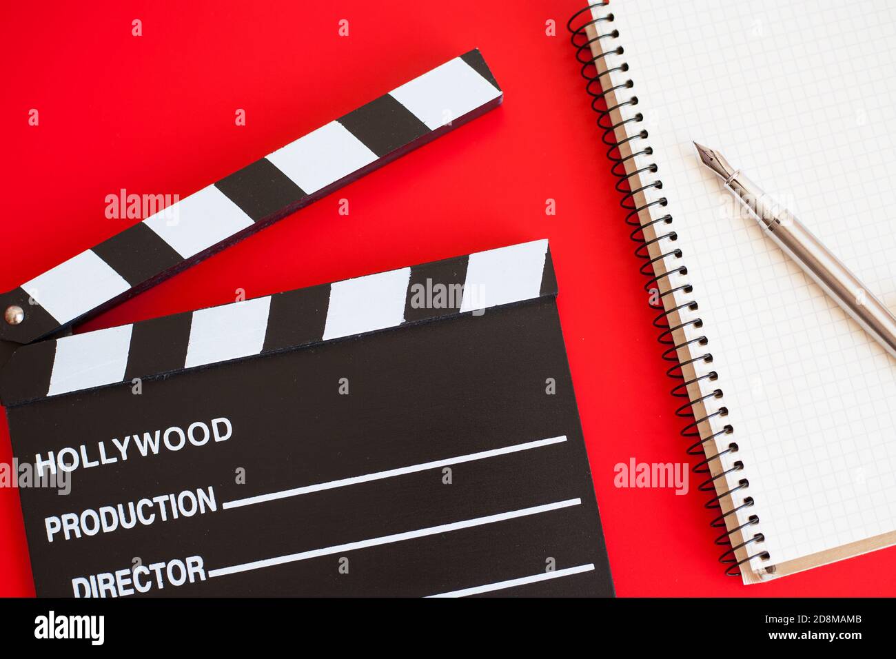 film clapper and pen notepad on red background Stock Photo - Alamy