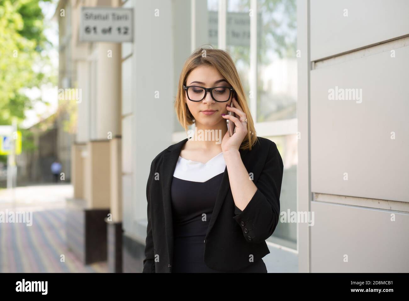 Upset businesswoman talking on cell phone outdoors near house office ...