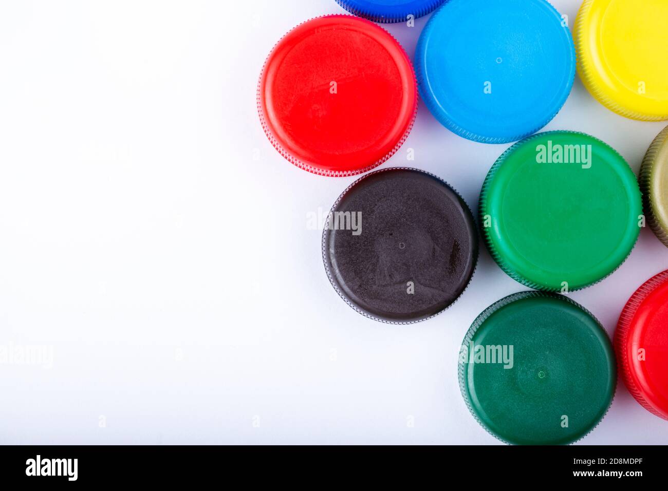 Group of multi colored bottle caps on a white background. Recycling and ...