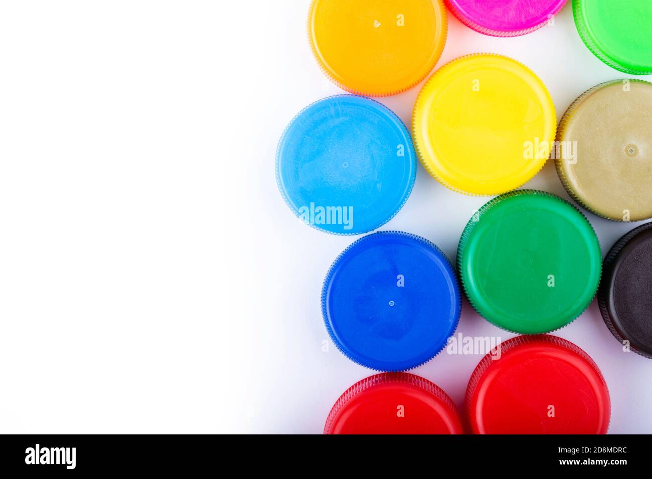 Group of multi colored bottle caps on a white background. Recycling and ...