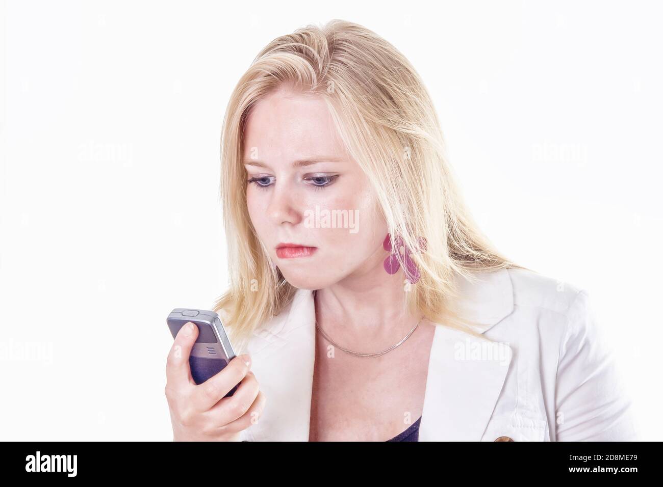 Attractive blonde with angry facial expression reading a text message ...