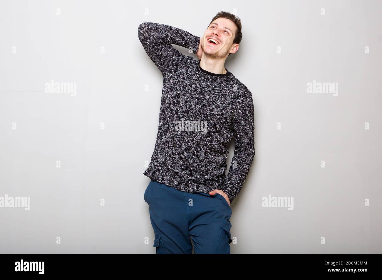 Portrait of happy young man laughing with hand behind head Stock Photo ...
