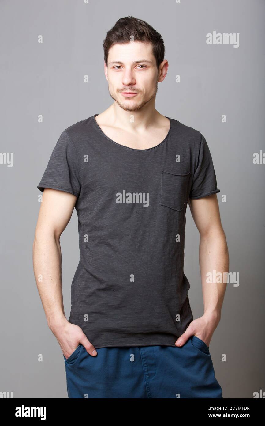 Portrait of cool male fashion model against gray background Stock Photo ...