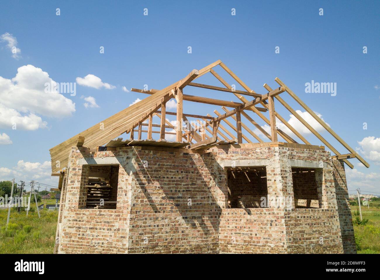 Aerial view of unfinished house with wooden roof frame structure under ...
