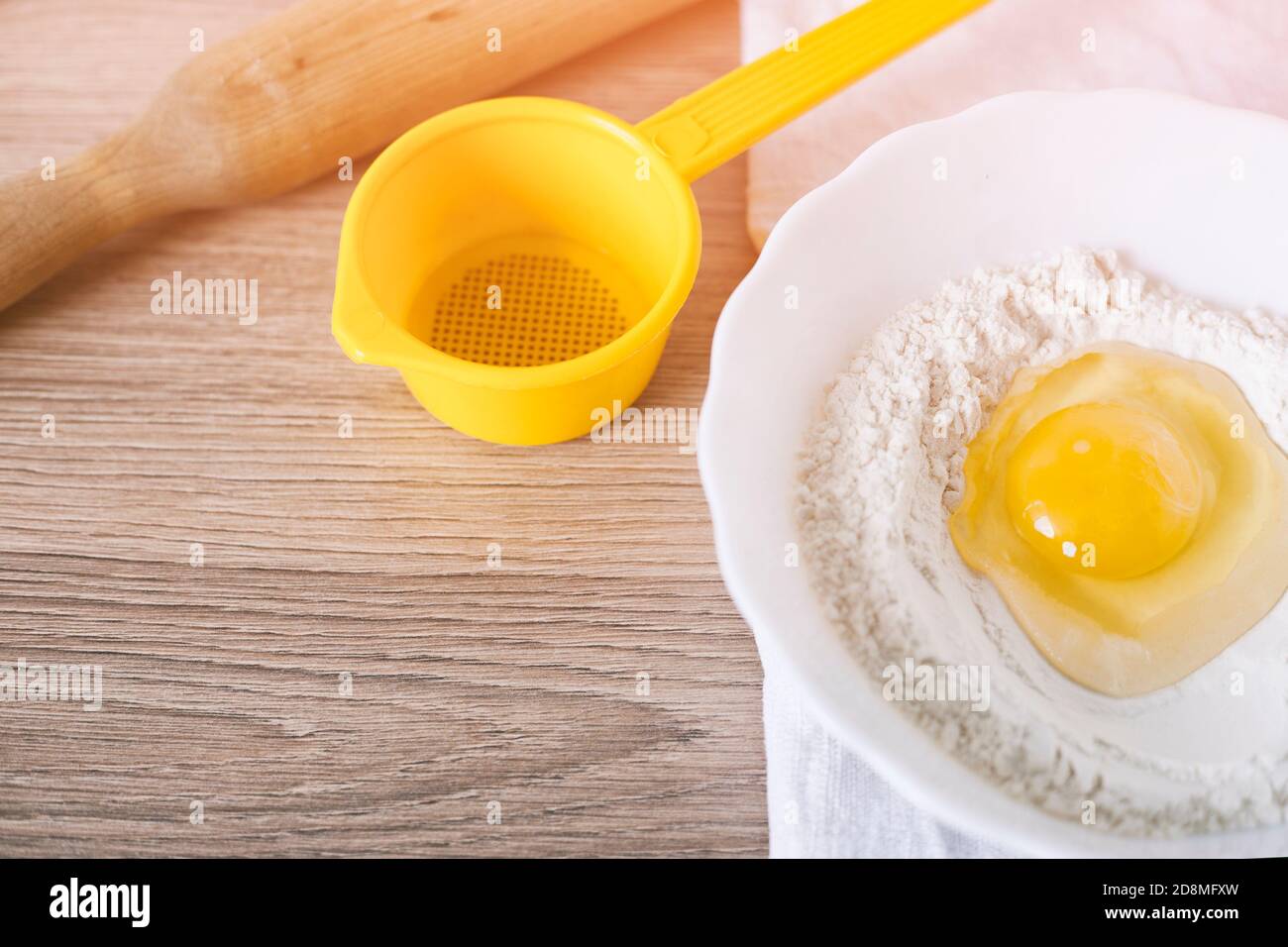 Process of baking, cooking. Flour with a yolk on wooden table. Rolling ...
