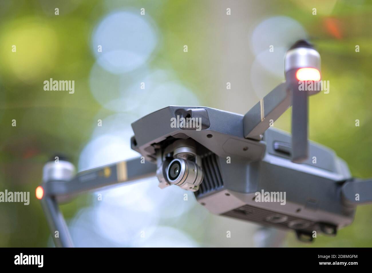 Drone copter with blurred propellers and video camera flying in air ...