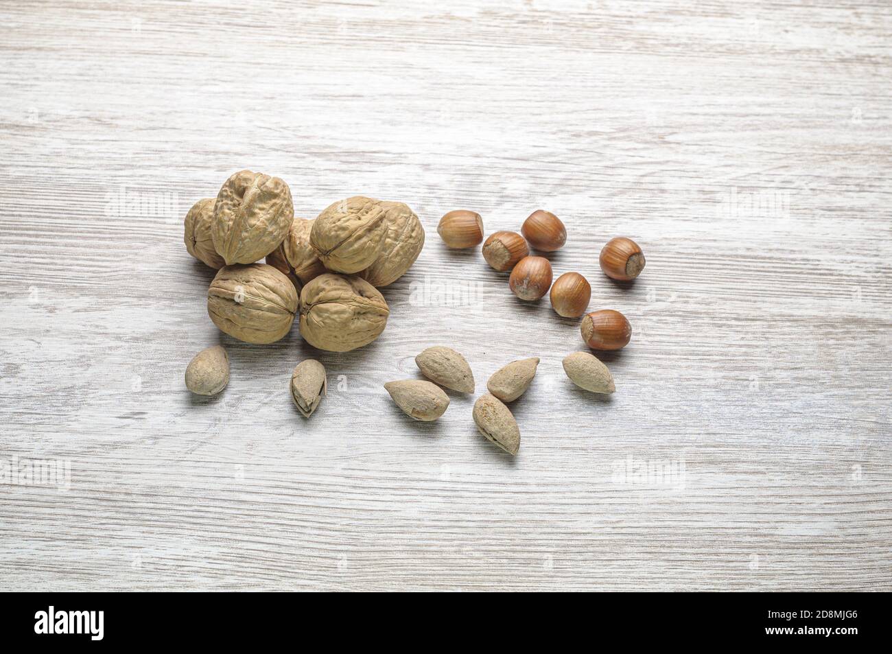 Walnuts, peanuts and hazelnuts on a wooden table Stock Photo - Alamy