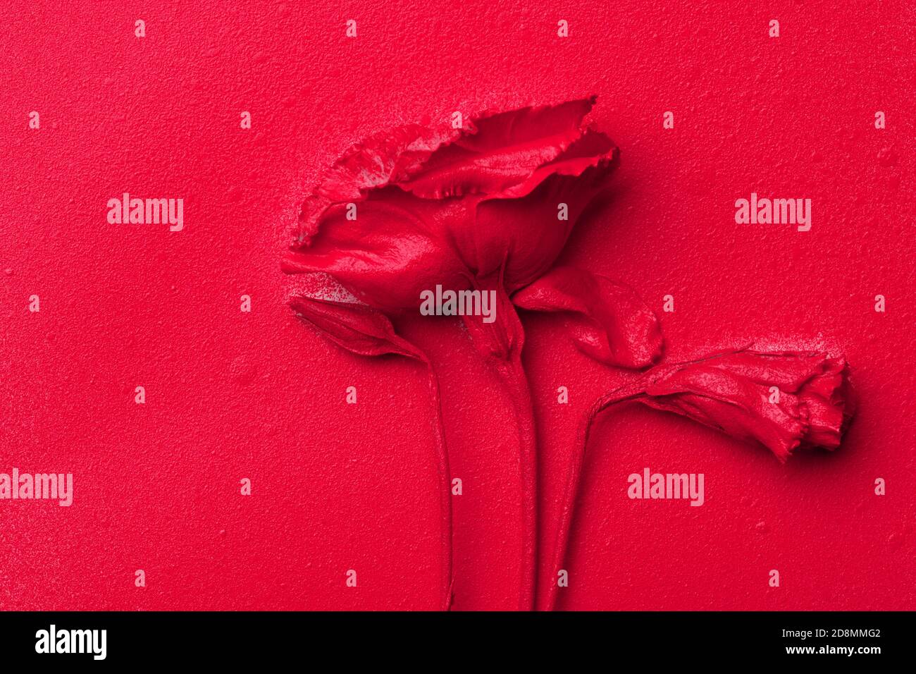 Bright spray painted red eustoma flower on a red paper background with ...
