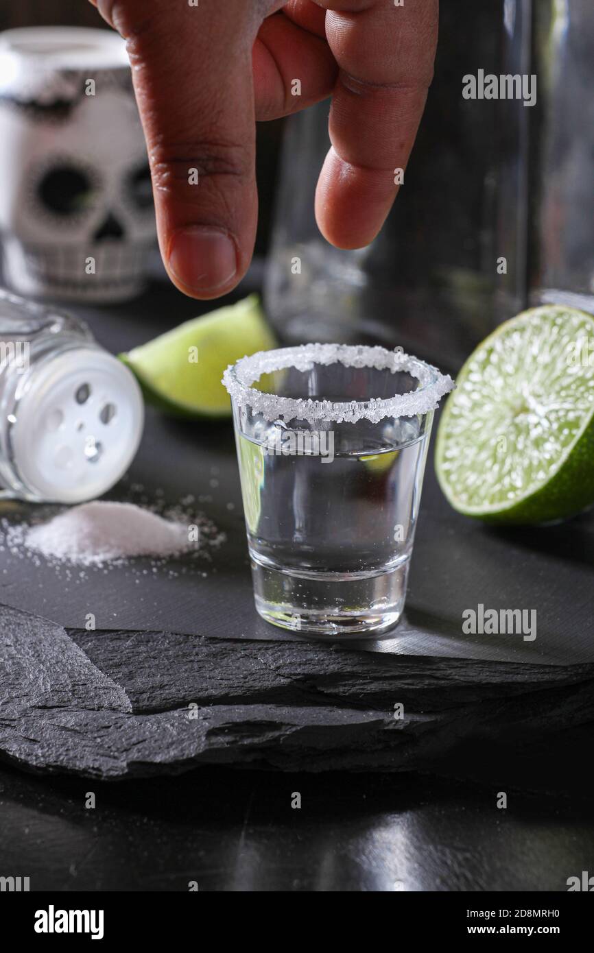 Hand taking the salty tequila jigger Stock Photo - Alamy