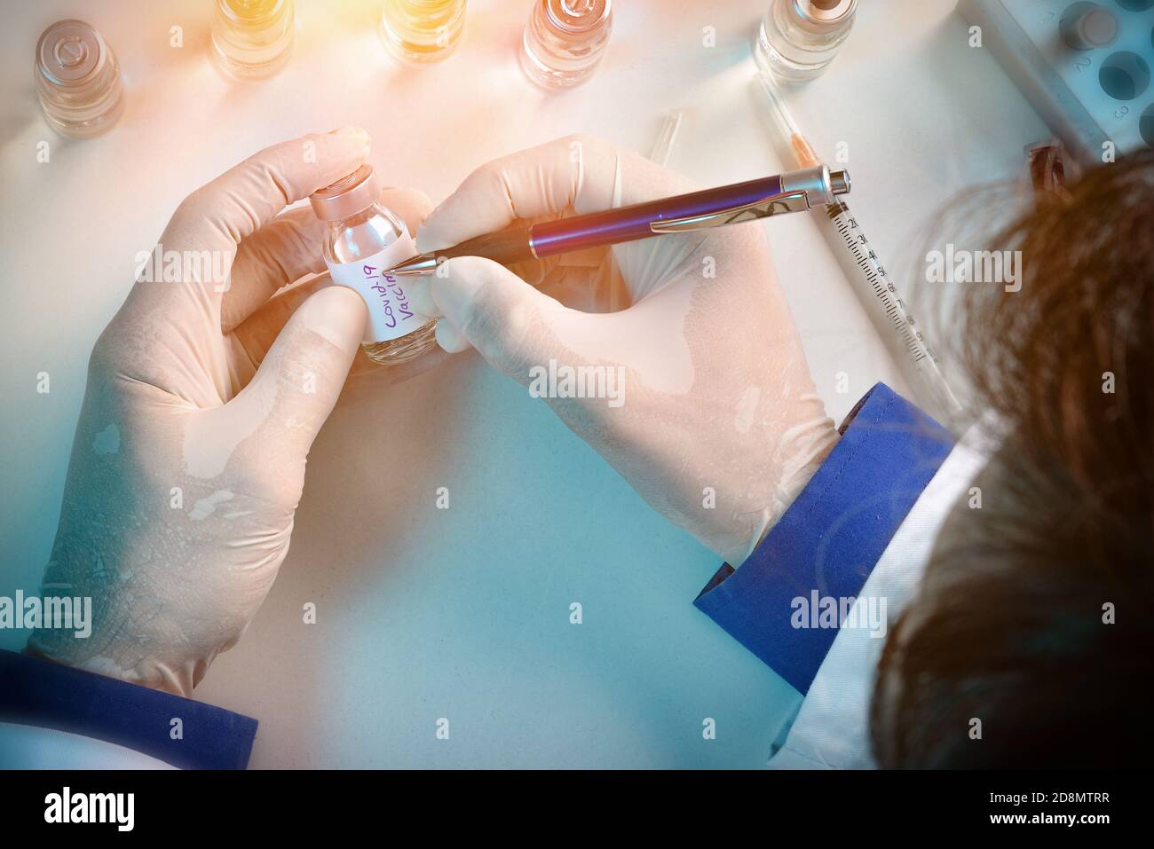 Laboratory staff writing on vials with covid-19 vaccine. Horizontal ...