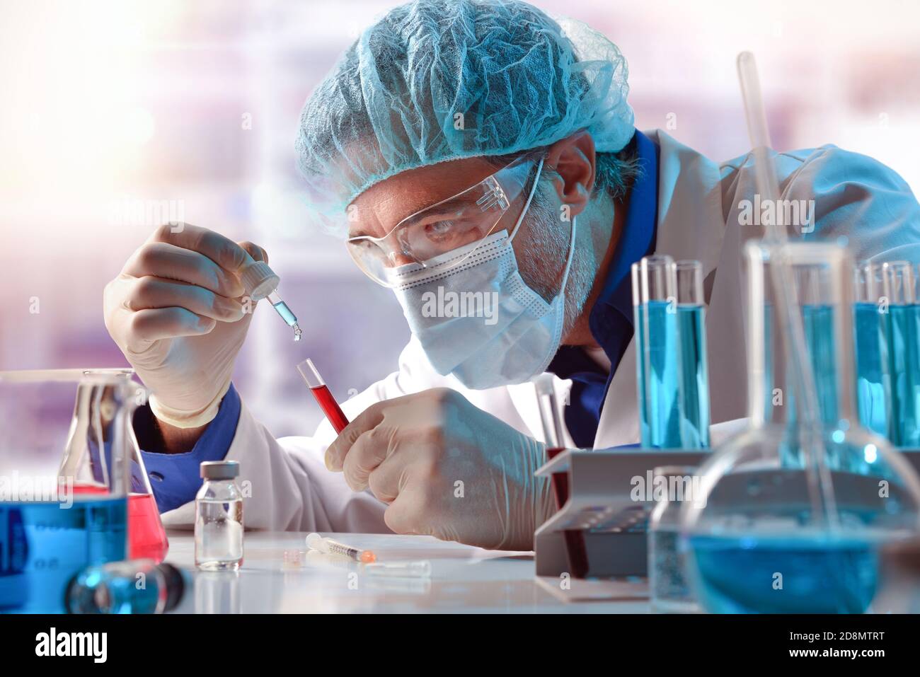 Researcher in laboratory pouring reagent with a pipette into sample ...