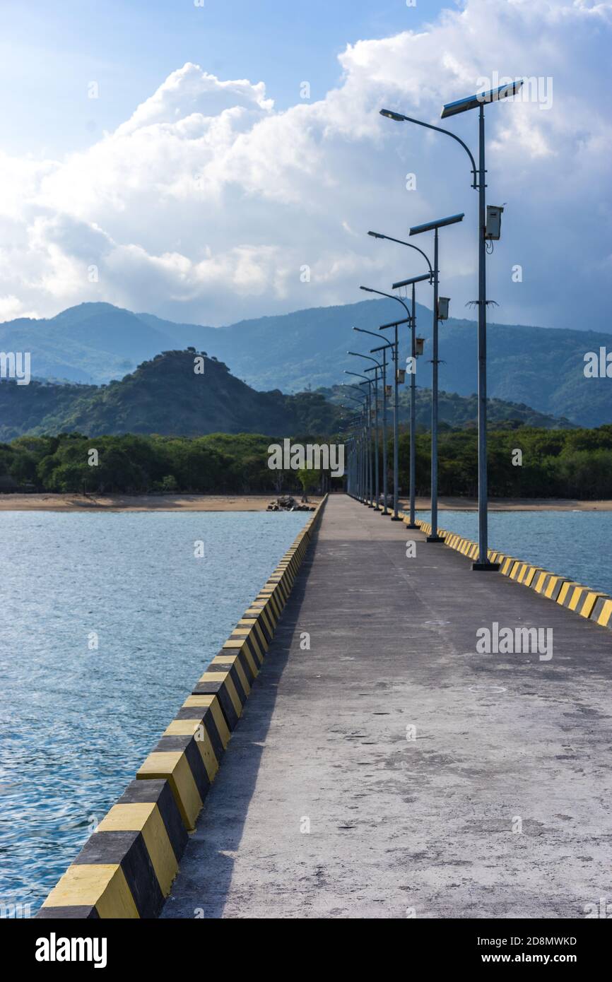 Newly built long pier on the sea with solar panels and lights, green ...