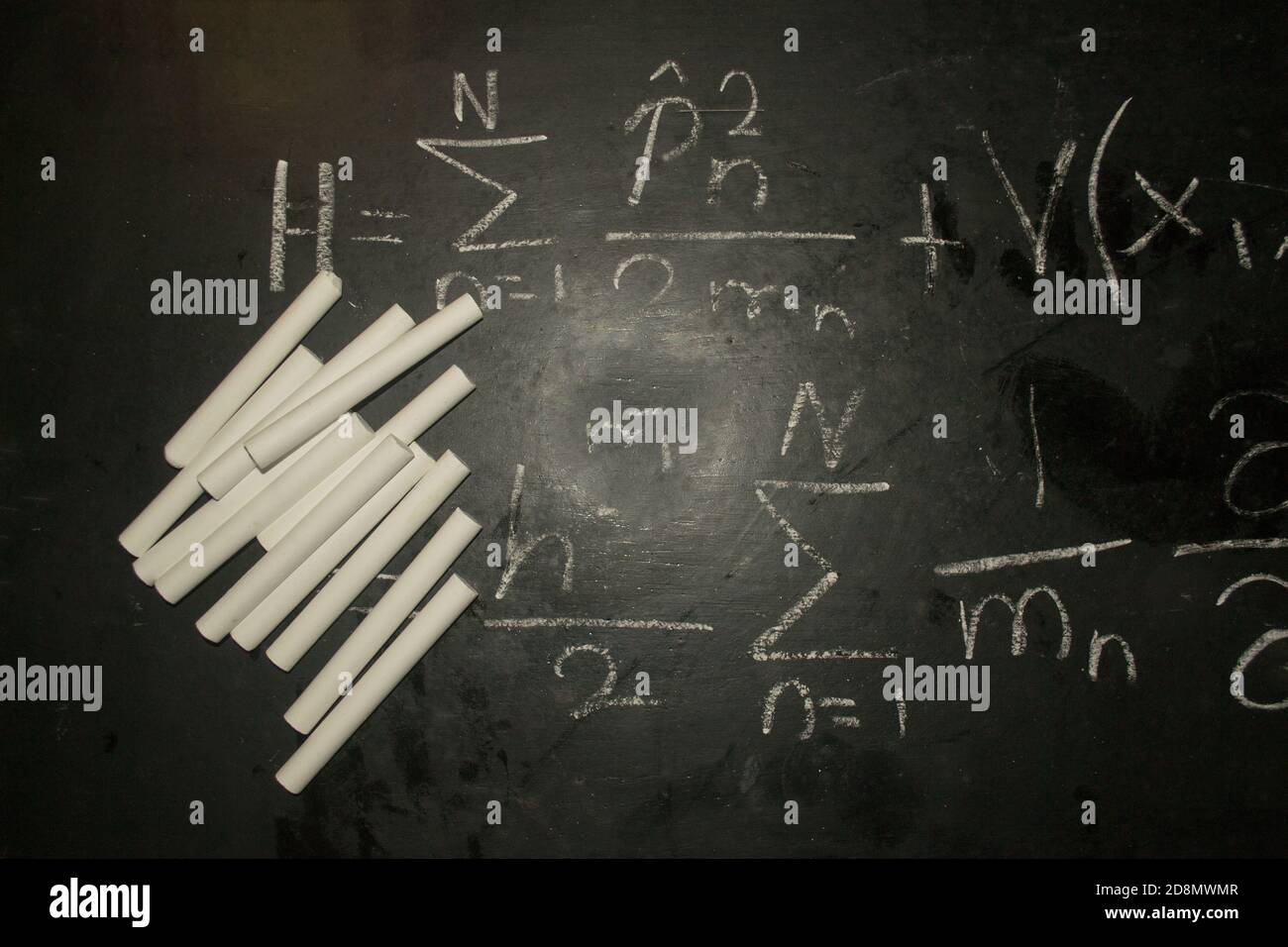close up image of a pile of white chalks on a black board with written ...