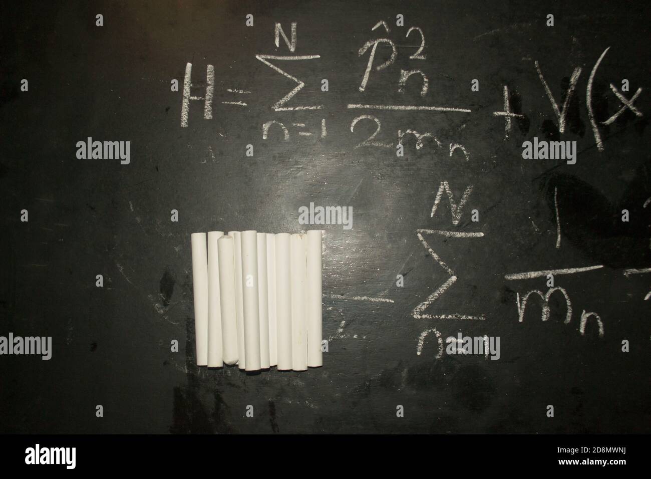 close up image of a pile of white chalks on a black board with written ...