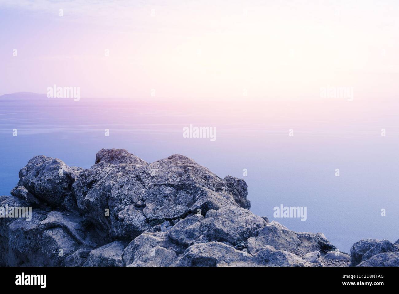 View from the cliff to the ocean. Sunrise or sunset with a haze over ...