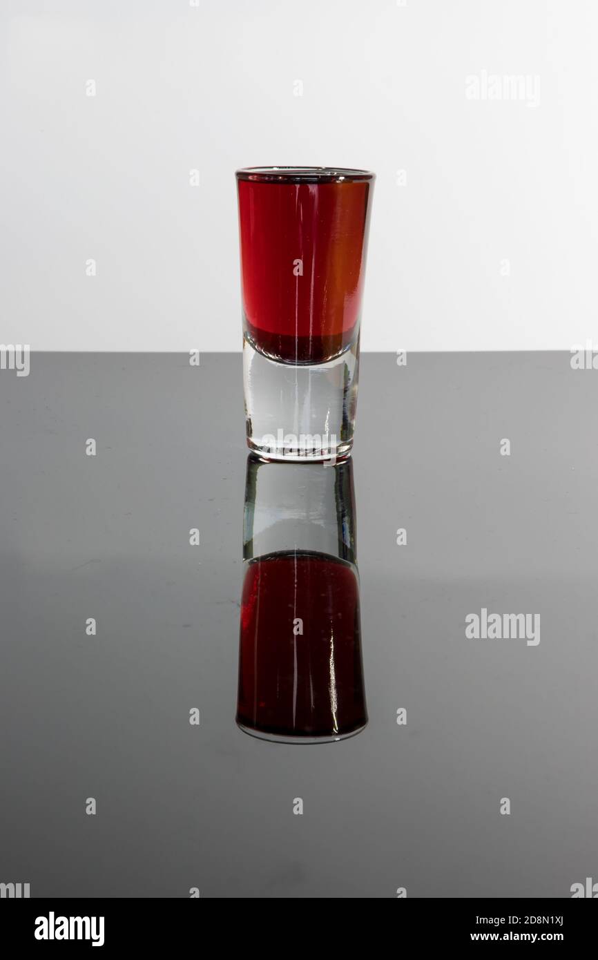 Alcohol in a shot glass reflected in a black glass table Stock Photo ...