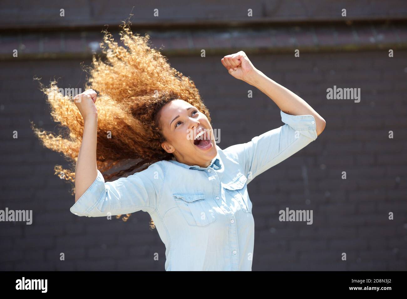 Portrait of happy young woman cheering with arms raised Stock Photo - Alamy