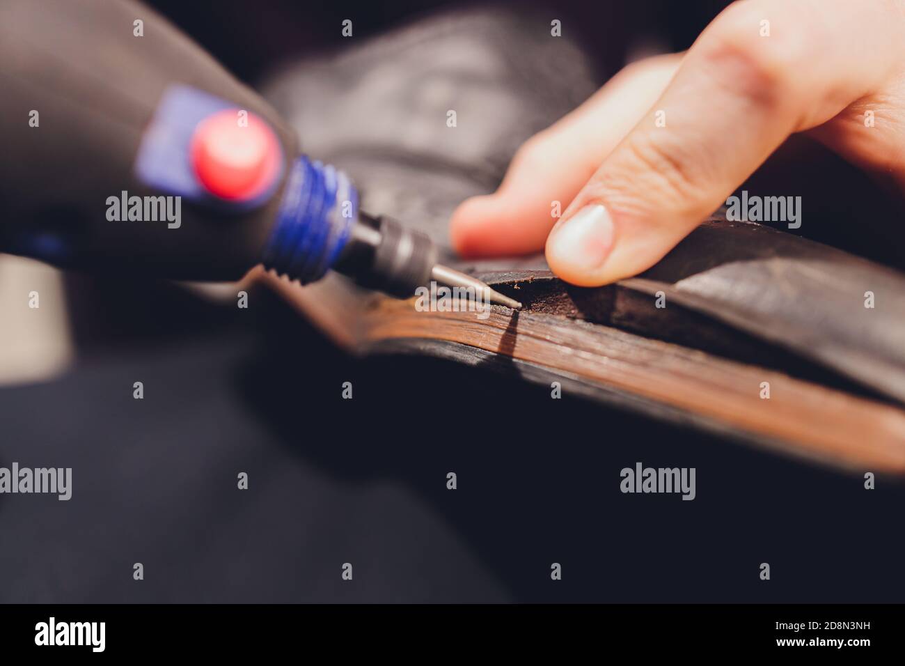A shoemaker cuts the sole of a Shoe with a shoemaker's automatic cutter ...