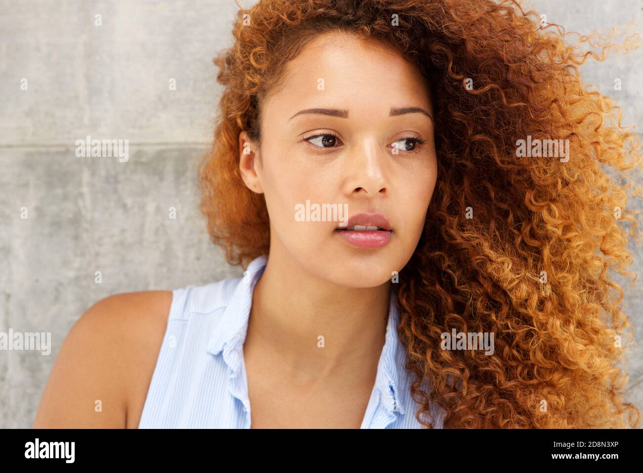Close Up Portrait Of Beautiful Young Woman With Curly Hair Glancing