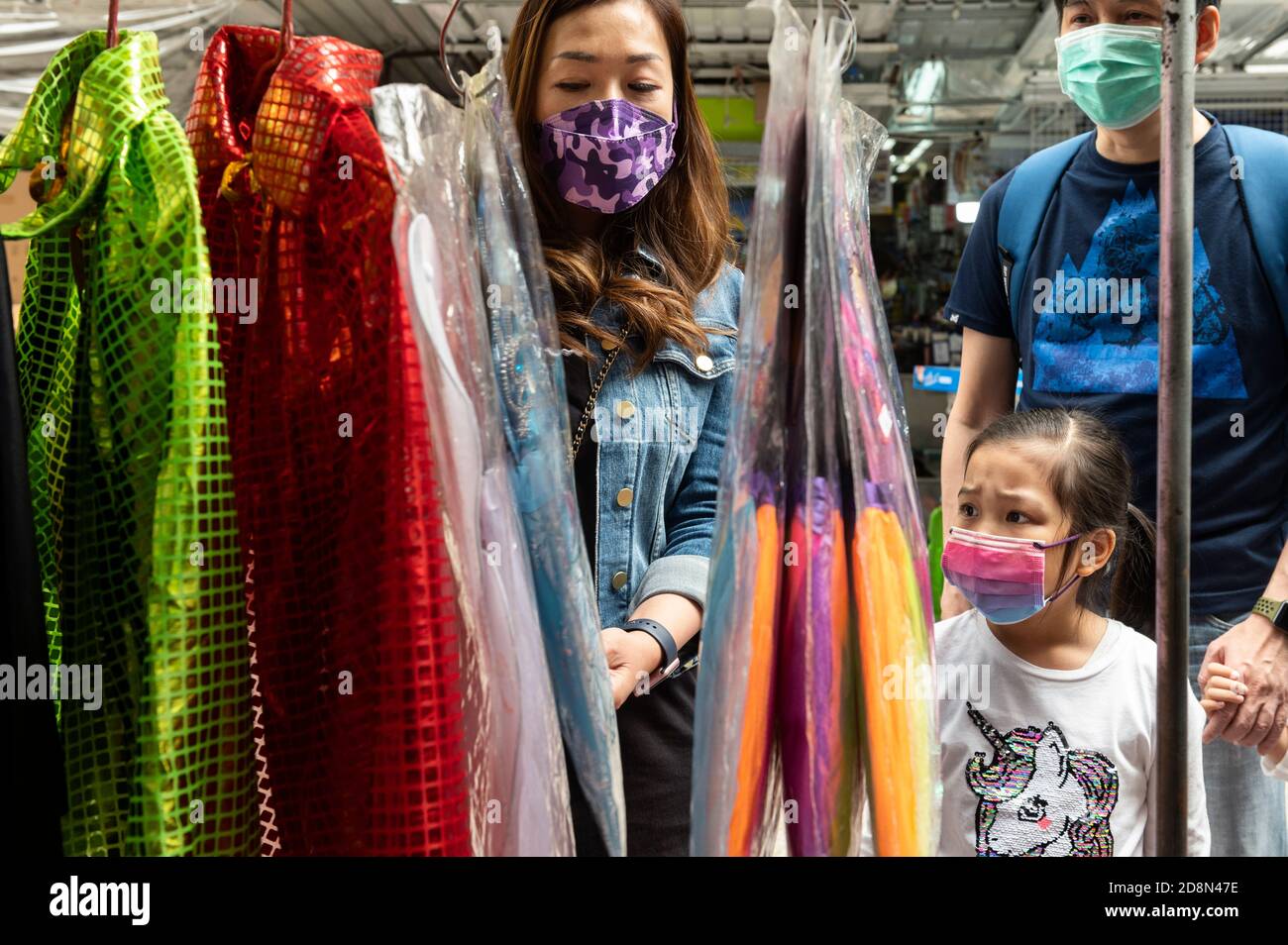 A family buys costumes at a gift and decorative product street store on ...