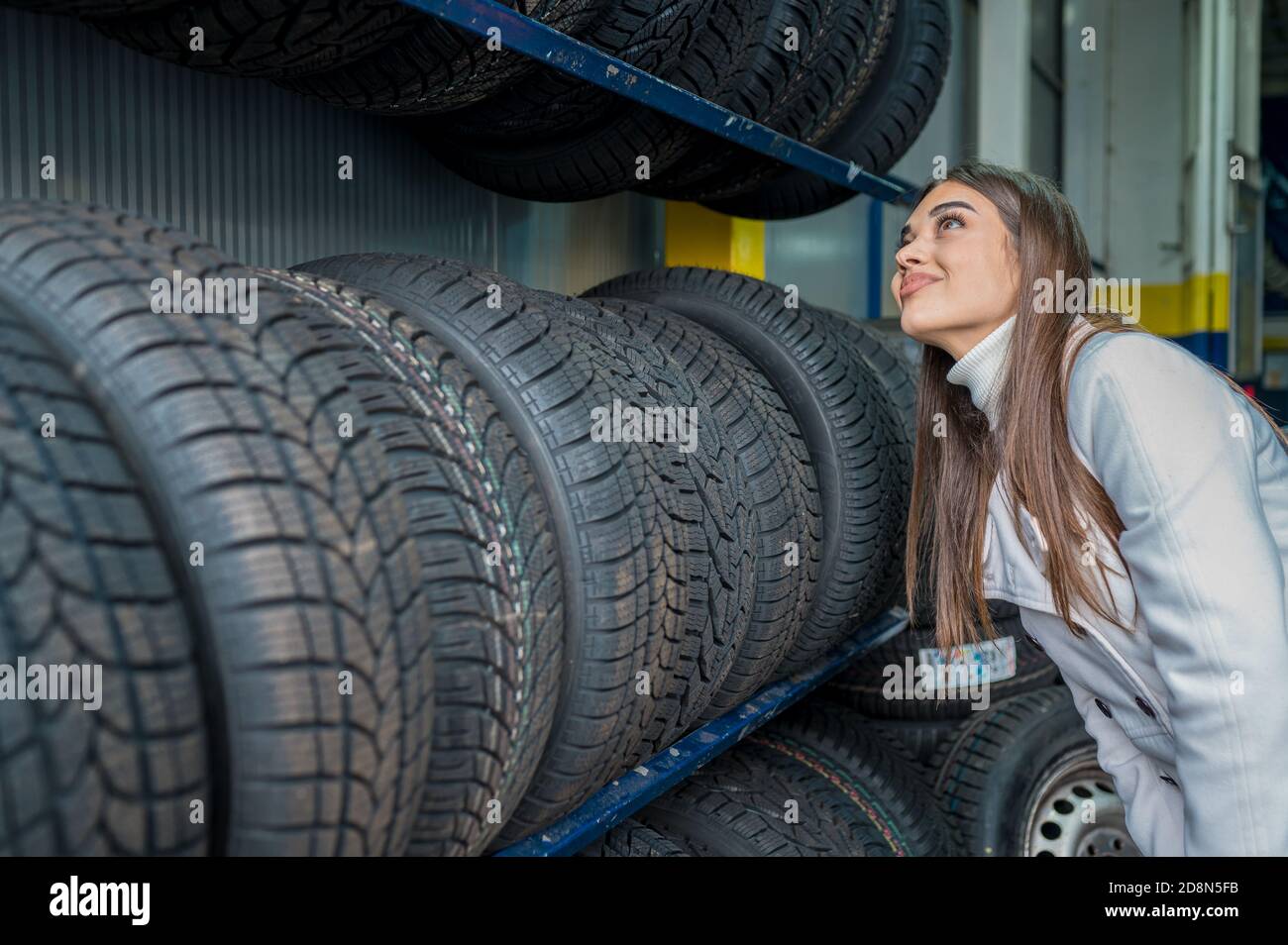Female looking at the tires in the garage Stock Photo - Alamy