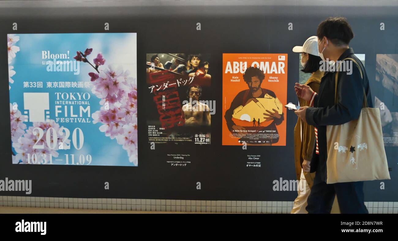 Tokyo, Japan. 31st Oct, 2020. People walk past movie posters for the ...
