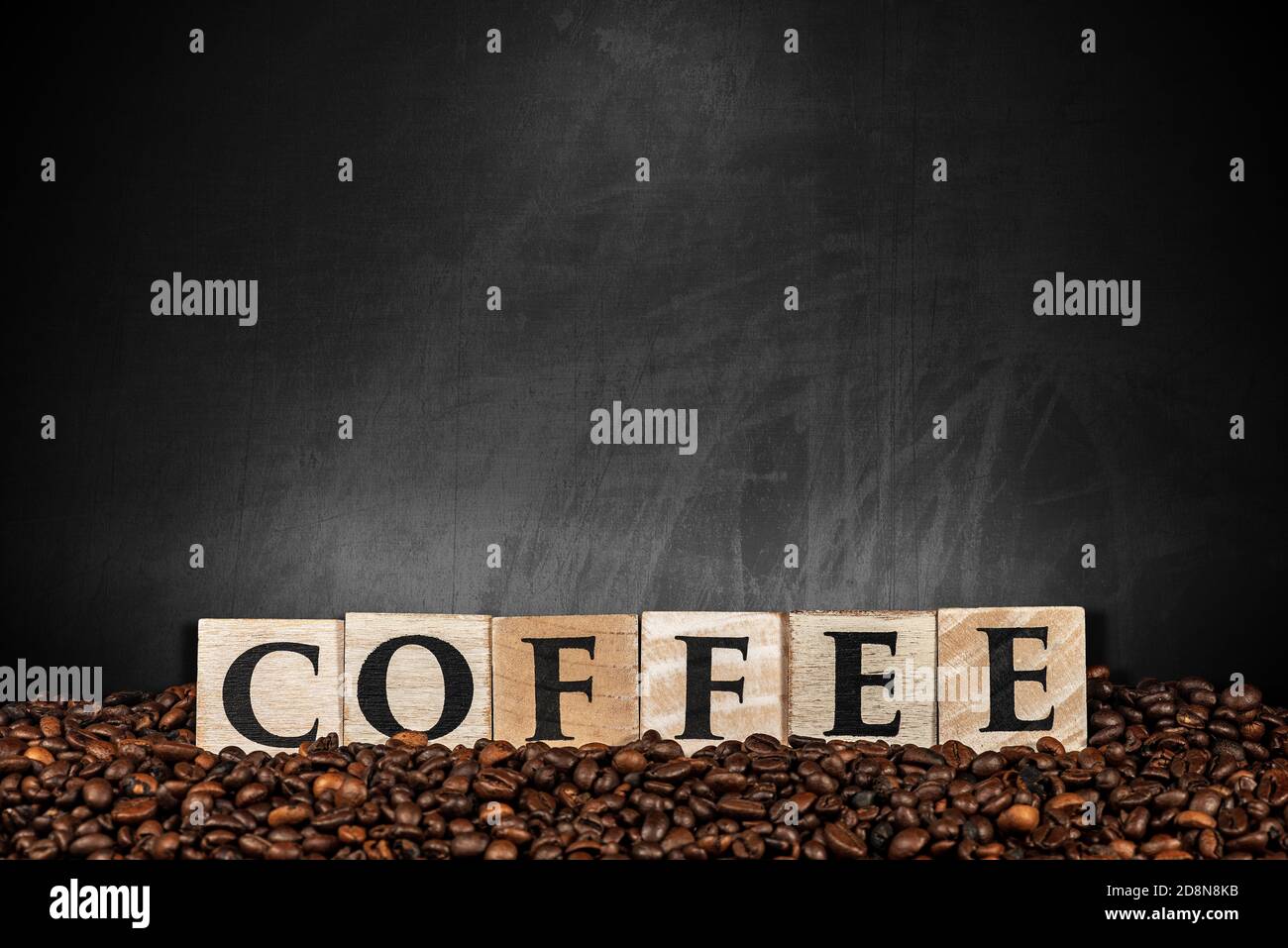 Heap of roasted coffee beans and the text Coffee made of wooden blocks ...