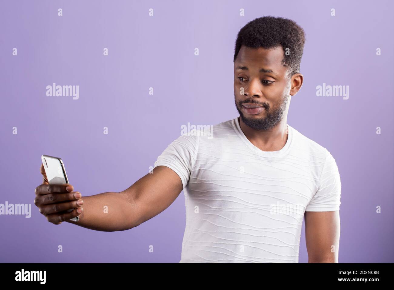 Photo of amazed puzzled black man holding modern cell phone, taking ...