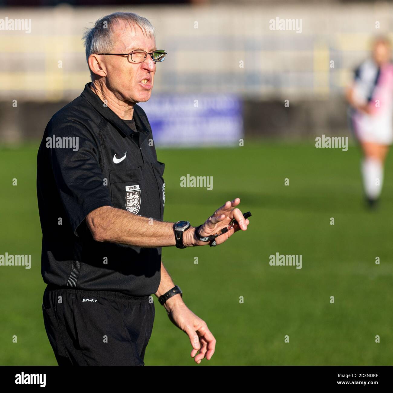 An English Football referee with his hand out speaking to a manager ...