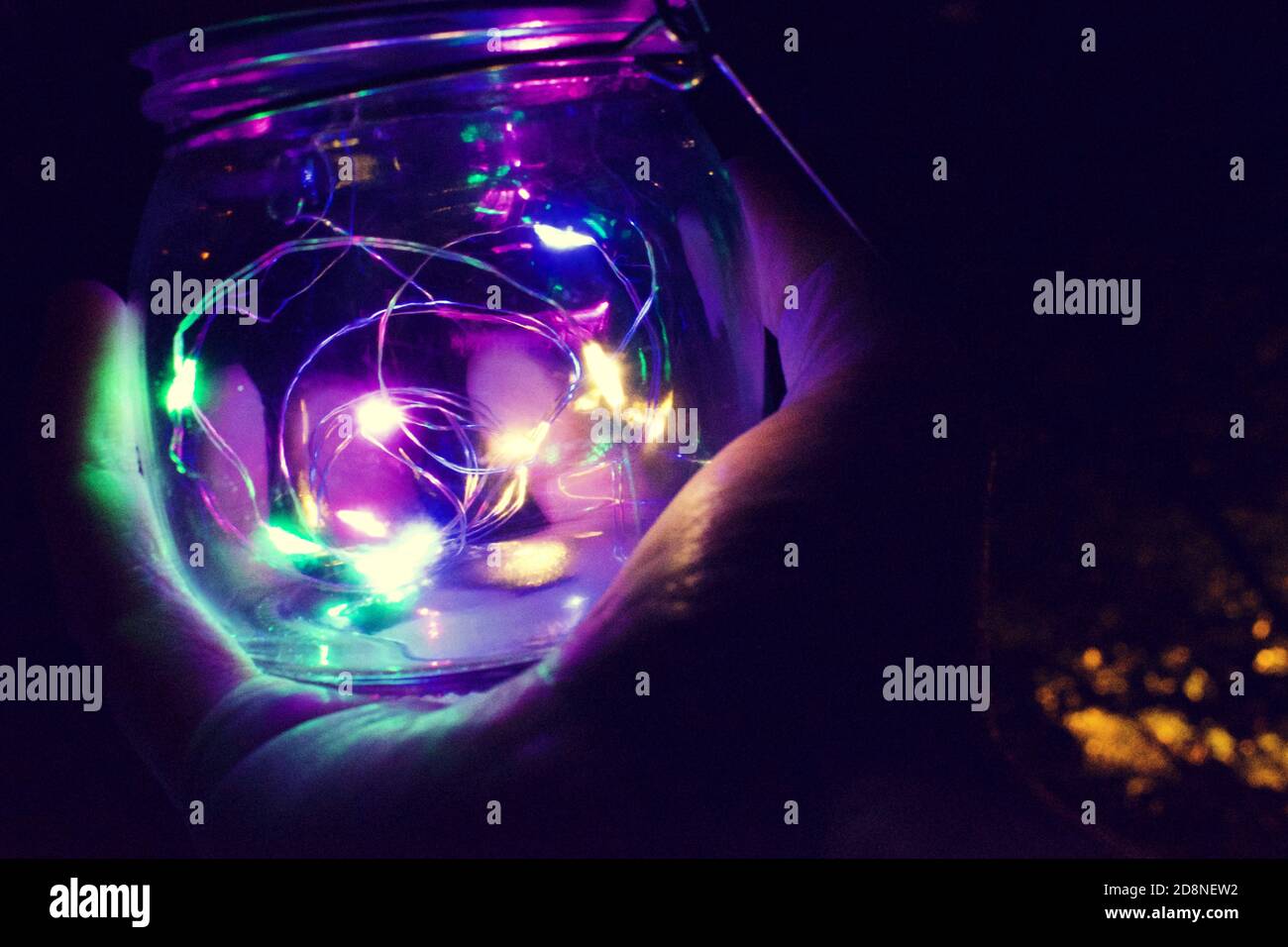 Hand holding mason Jar filled with neon LED lights inside Stock Photo ...