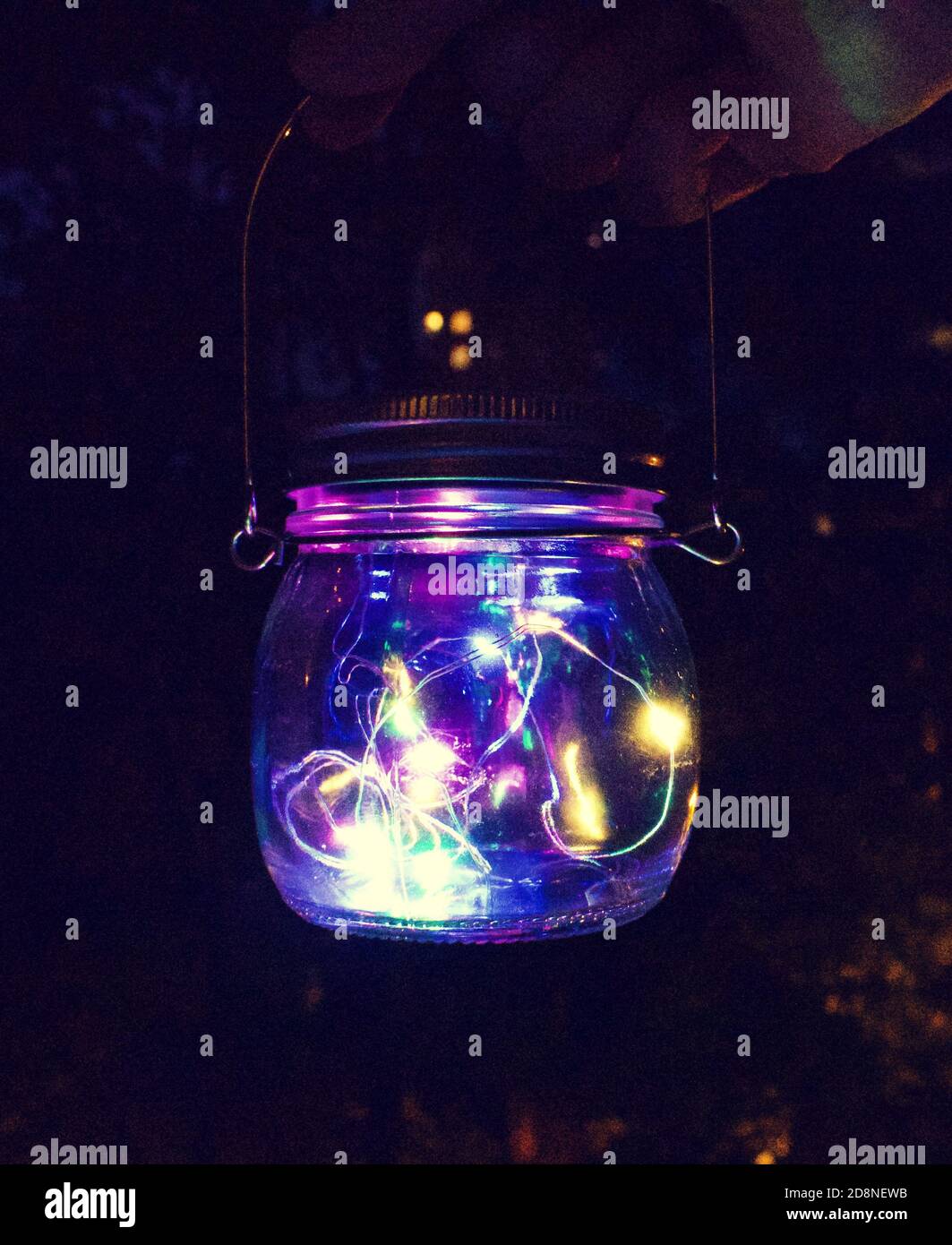 Hand holding mason Jar filled with neon LED lights inside Stock Photo ...