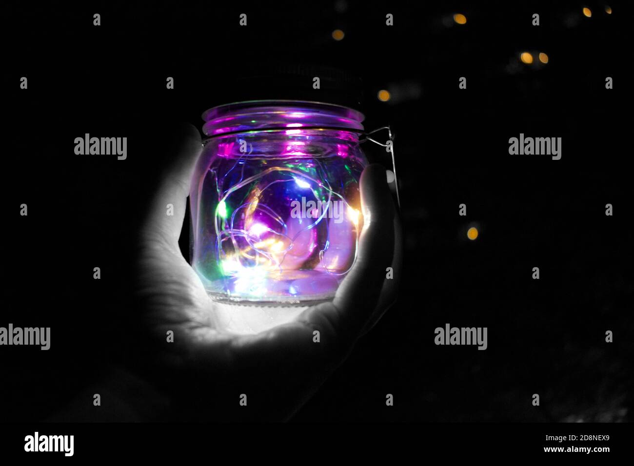 Hand holding mason Jar filled with neon LED lights inside Stock Photo ...