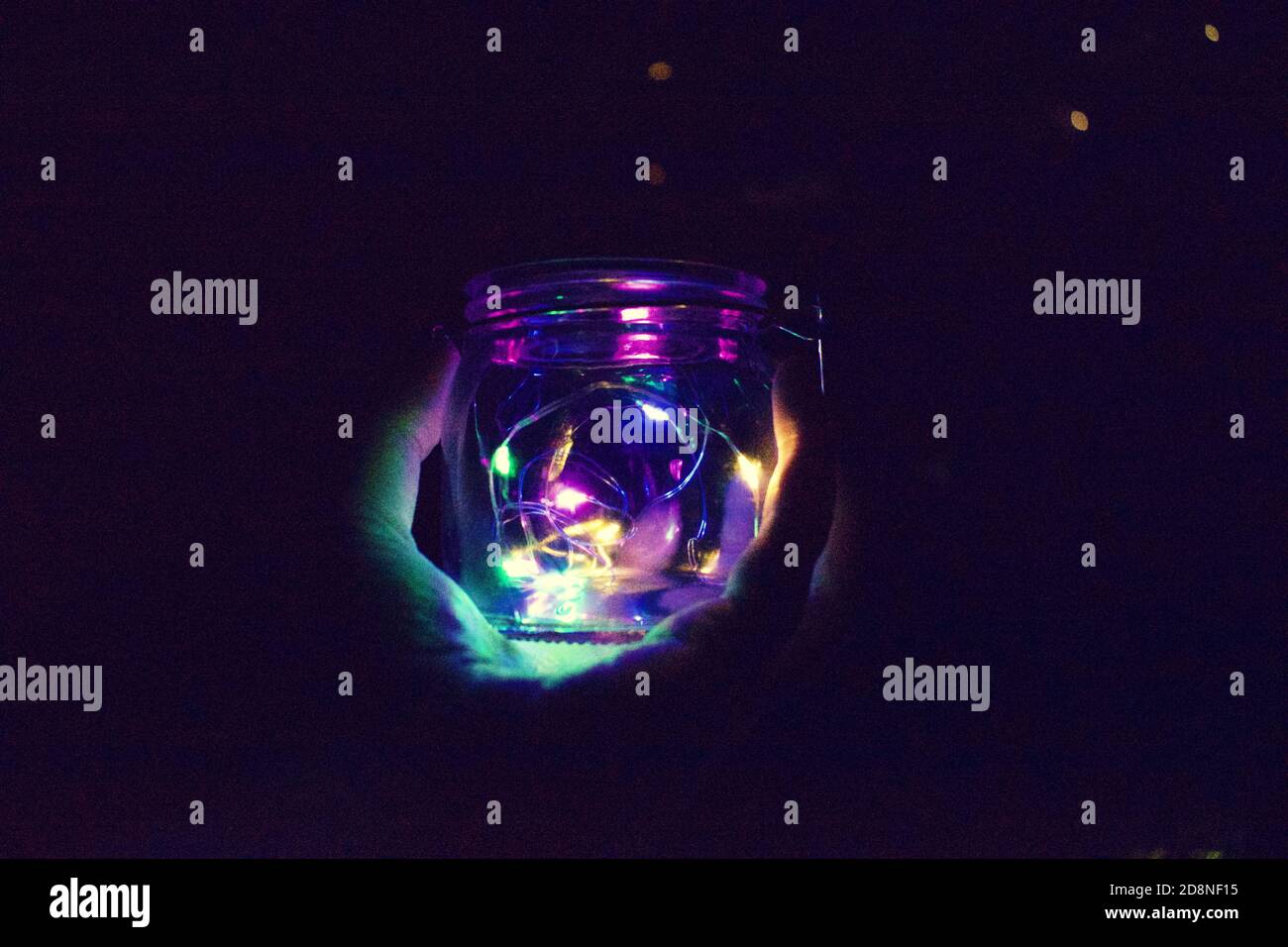 Hand holding mason Jar filled with neon LED lights inside Stock Photo ...