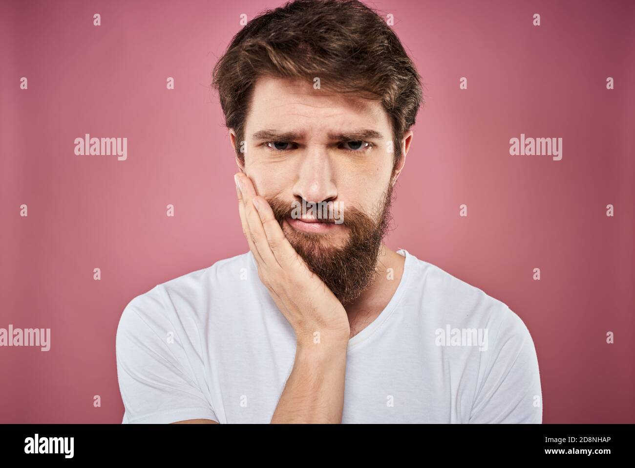 bearded man in white t-shirt emotions displeased facial expression ...