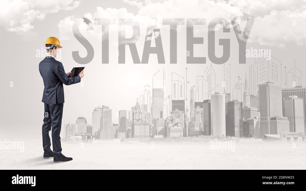 Young businessman with hard hat and STRATEGY inscription, new business ...