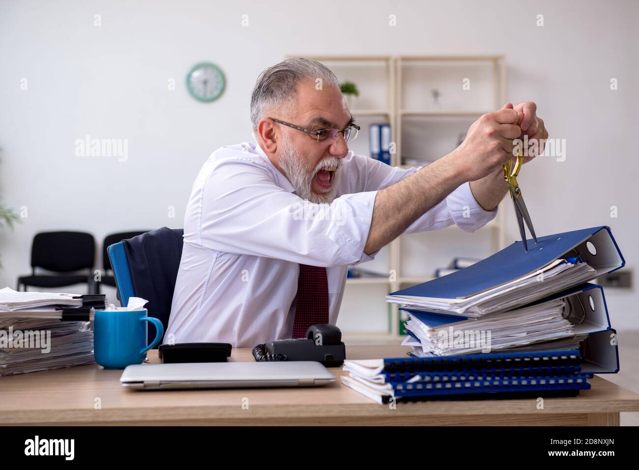 Aged employee unhappy with excessive work Stock Photo - Alamy